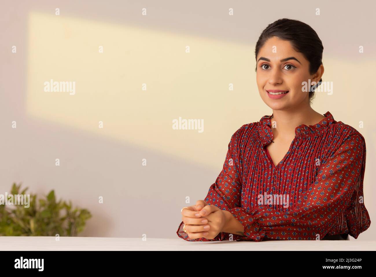 Portrait of a young woman looking elsewhere with holding hands together ...