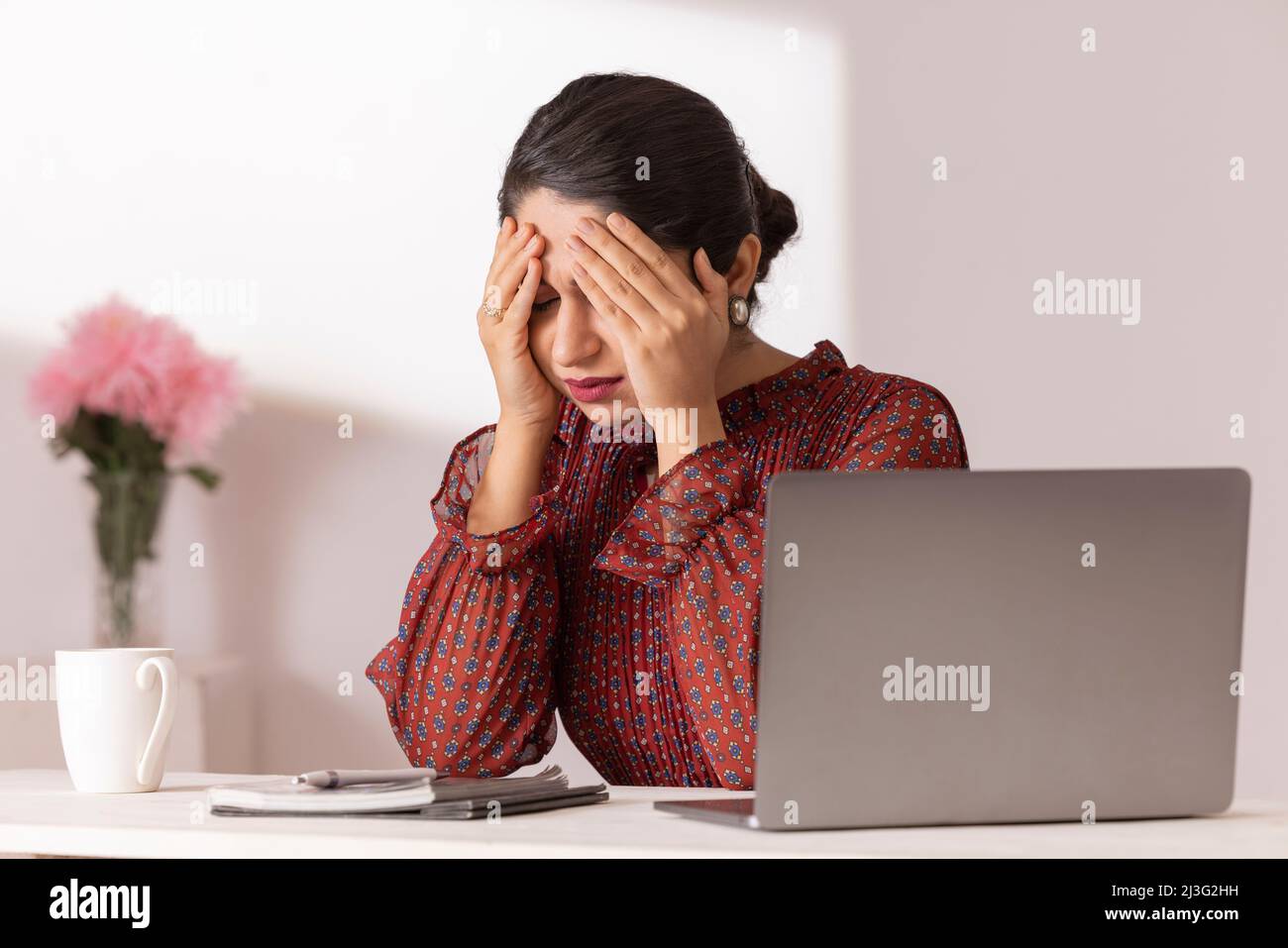 Portrait of an exhausted working woman with laptop in office Stock ...