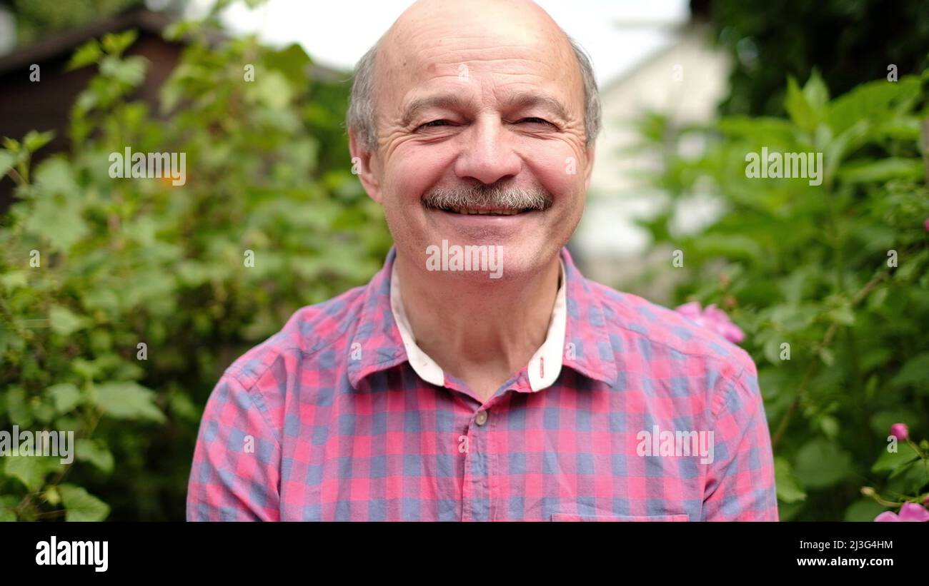 Happy smile senior elderly man in the park outdoors. Positive facial ...