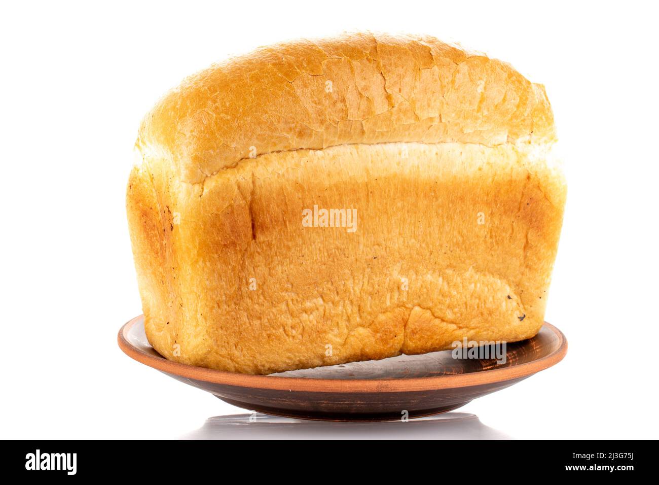One loaf of flavored wheat bread on a clay plate, close-up, isolated on ...