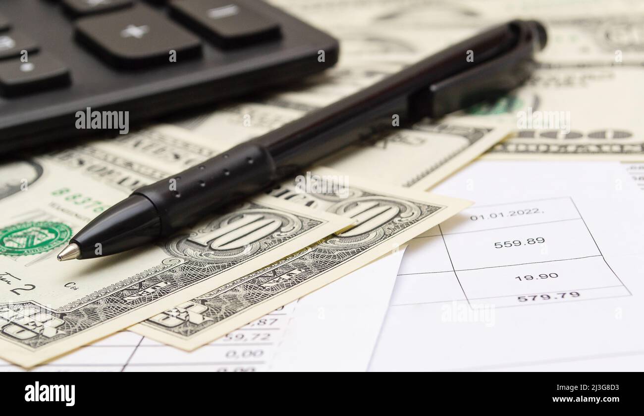 Calculator, money, pen and different bills close-up. Business ...