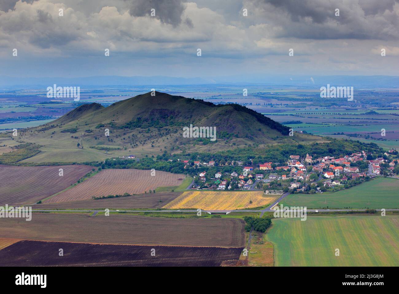 Hill with clouds. Beautiful morning landscape. Village below the hill ...