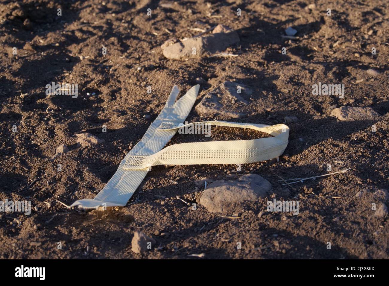 Plastic waste or pollution, broken bag handle thrown away in nature ...