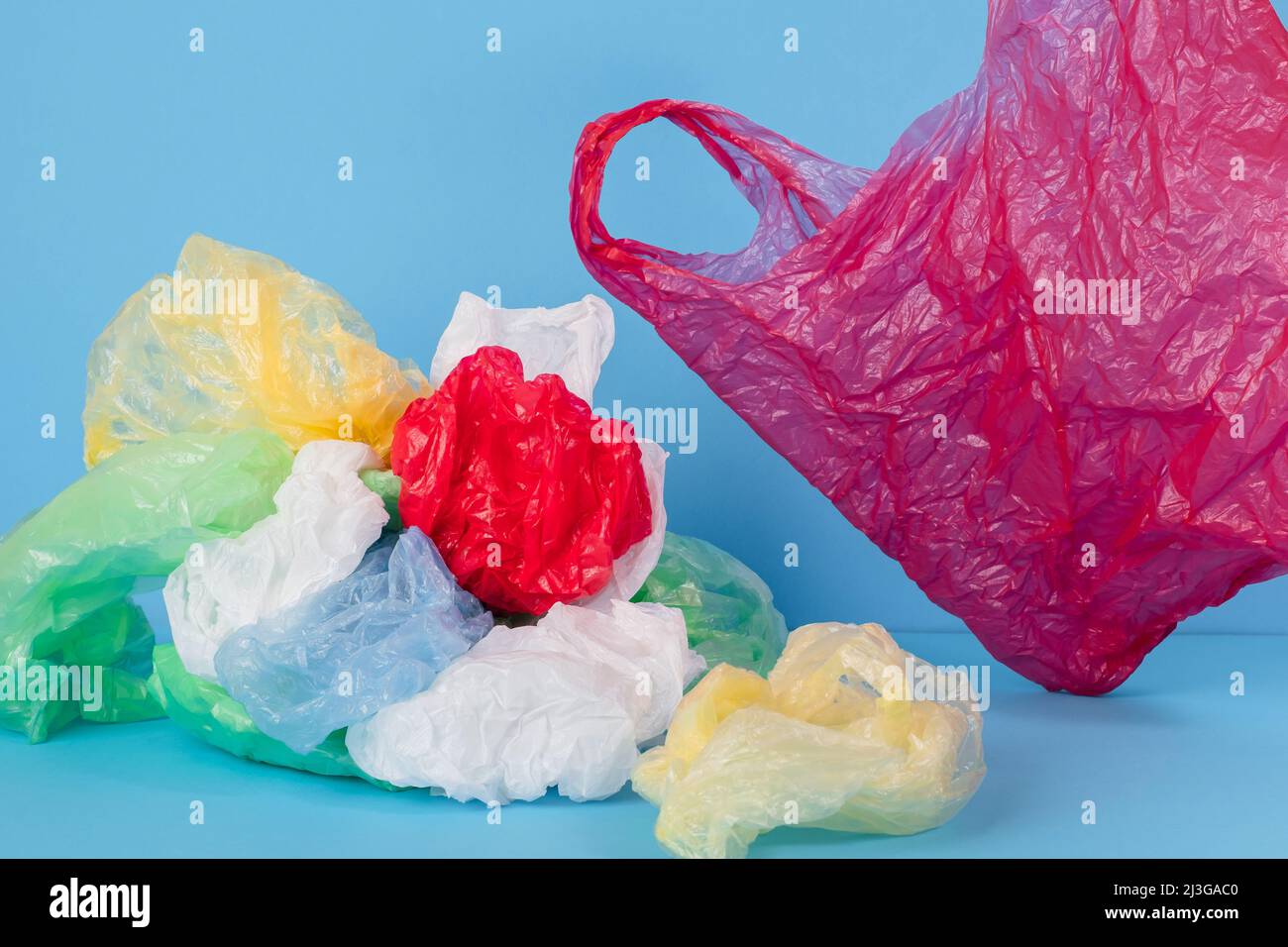 Plastic bags and plastic wraps of different colors on a blue background ...