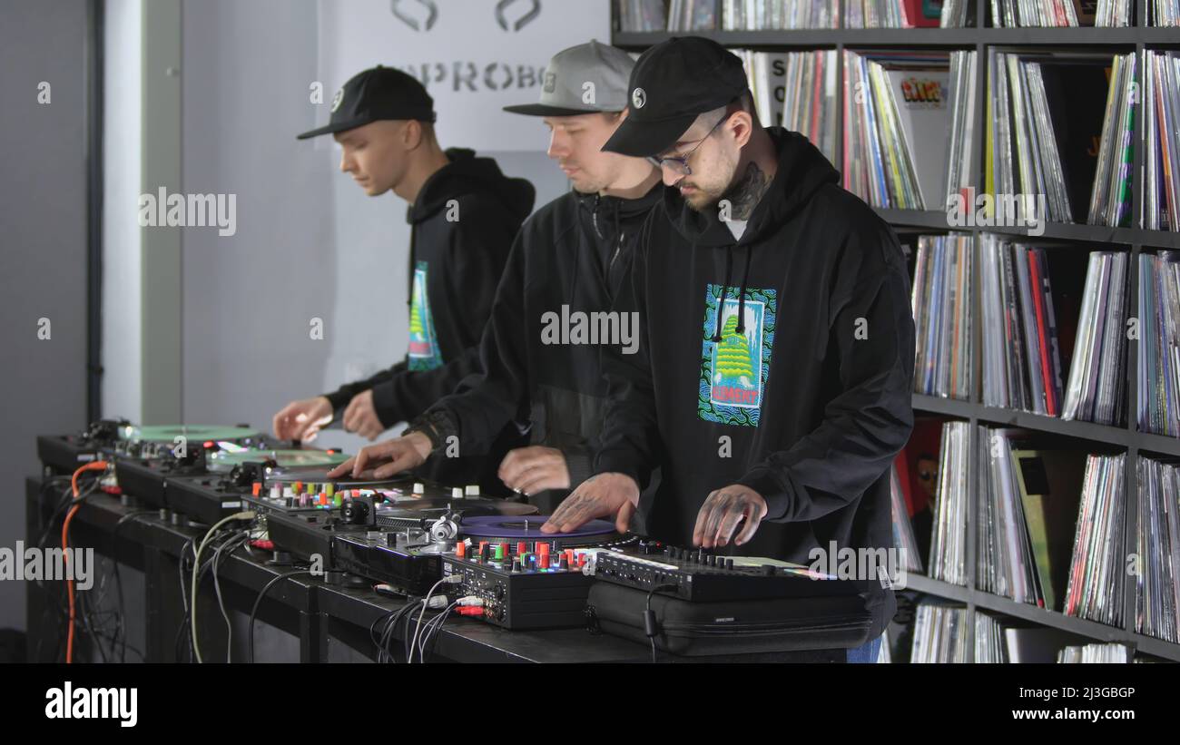 Two DJs are mixing music on console. Art. People are setting up music ...