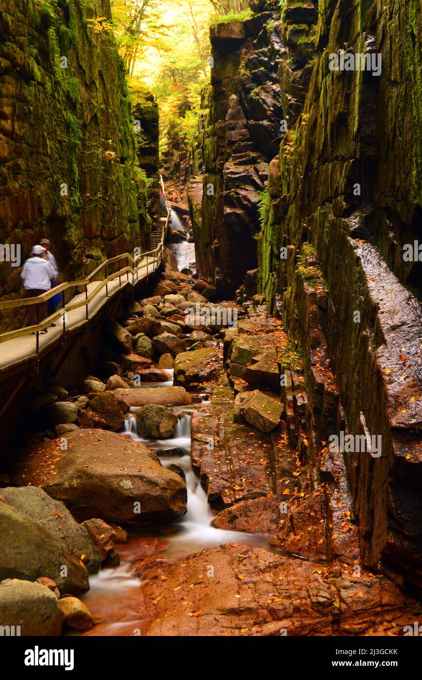 Walkers travel along a wooden boardwalk through the Flume Gorge in the ...