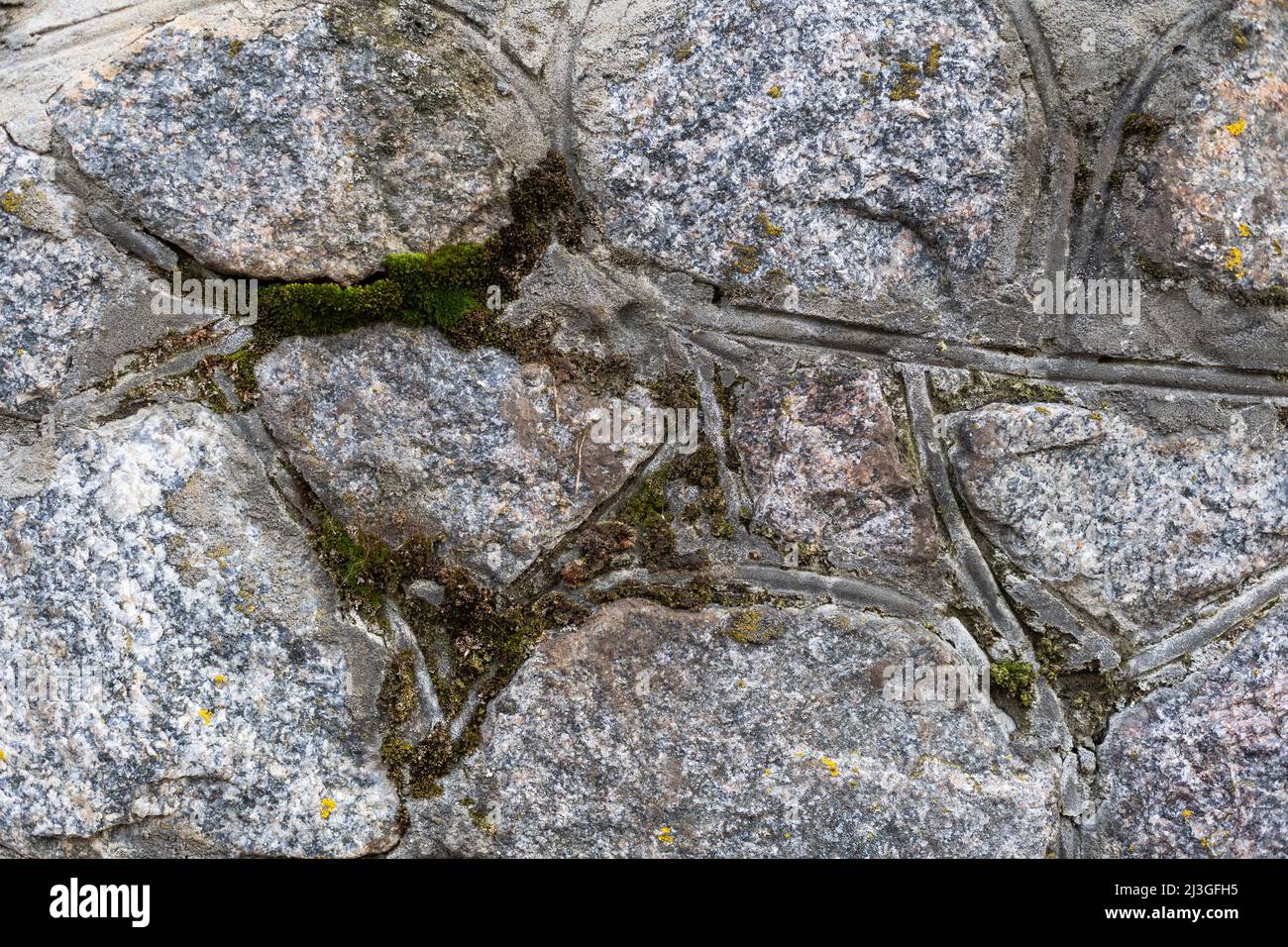 Aged and weathered white stone wall that has different size squares ...