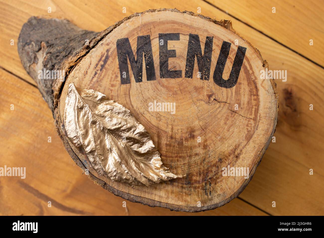 menu written on a slice of wood , with a golden leaf, restaurant menu ...
