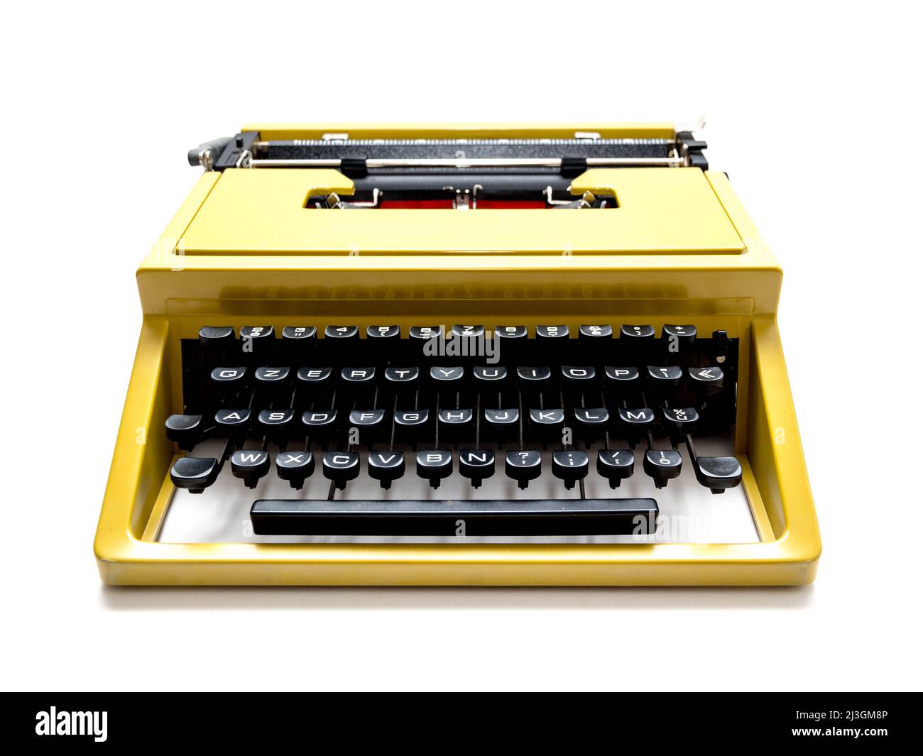 Studio photo of a vintage mustard yellow typewriter on a white ...