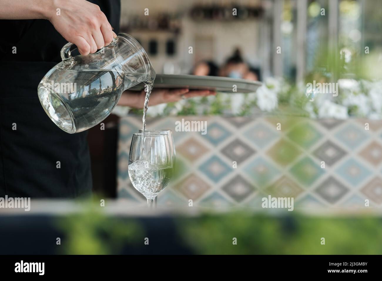 Close Up of Female Waiter Pouring Water to the Glass in Restaurant ...