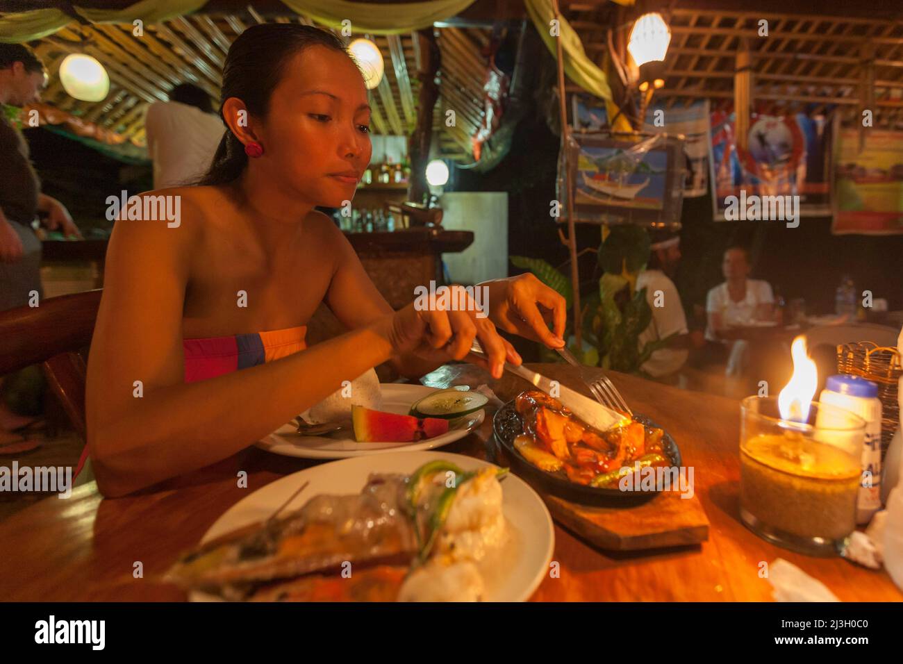 Philippines, Palawan, El Nido, young Filipino woman enjoys a meal of ...