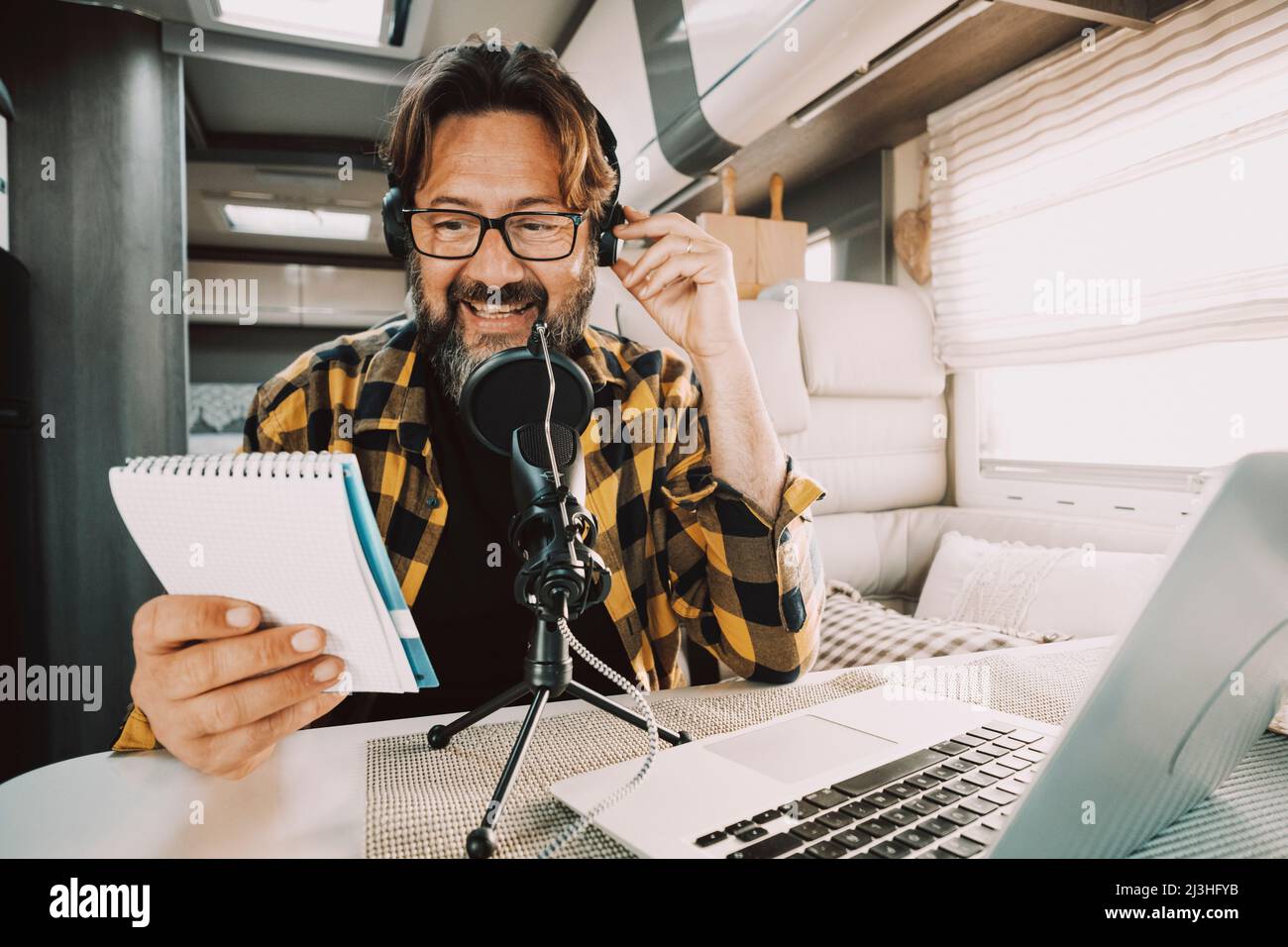 Portrait of handsome adult man speaking to microphone to record online ...