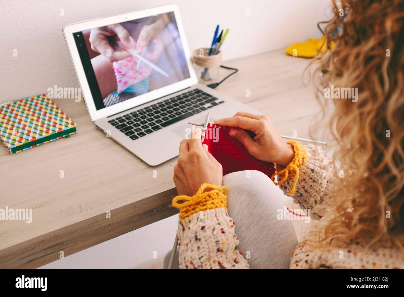 Woman at home doing knit work watching online tutorial class lesson on ...