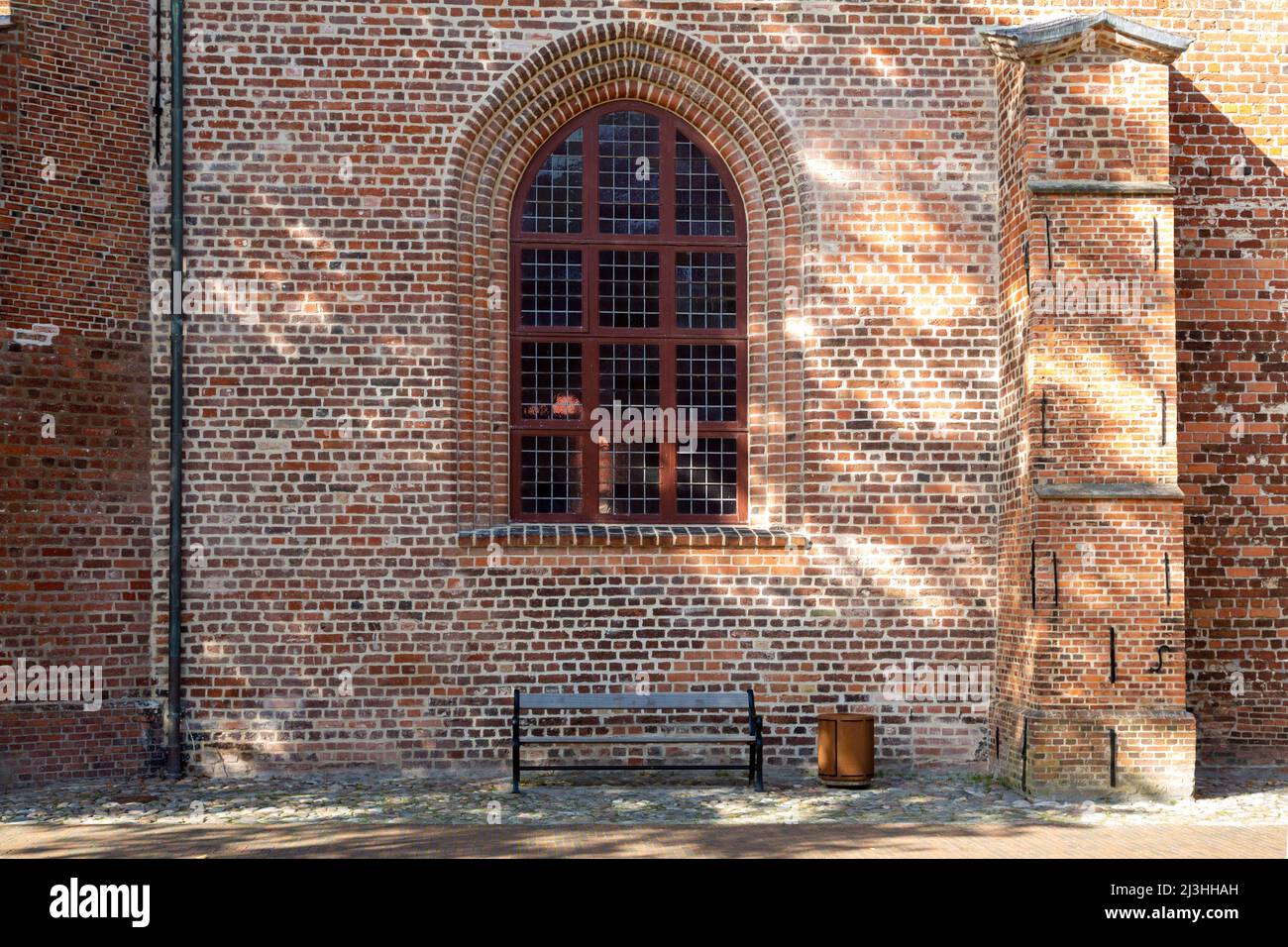 Rest area with bench against a brick wall with round arch window Stock ...