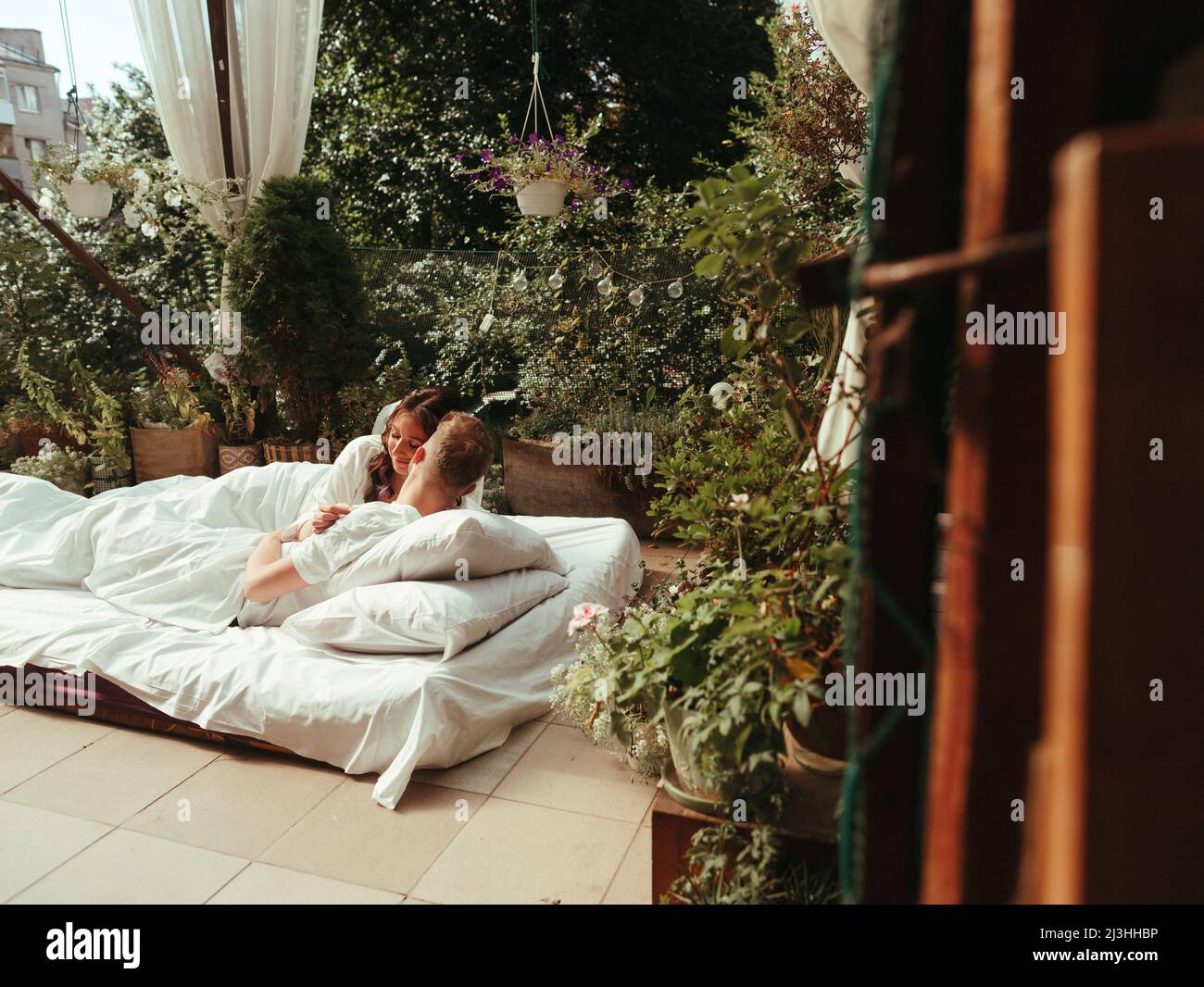 loving married couple lie on bed in hotel, relax together. man and ...