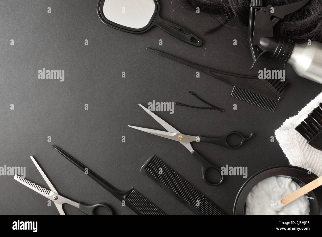 Set of hairdressing tools and styling on black table. Top view ...