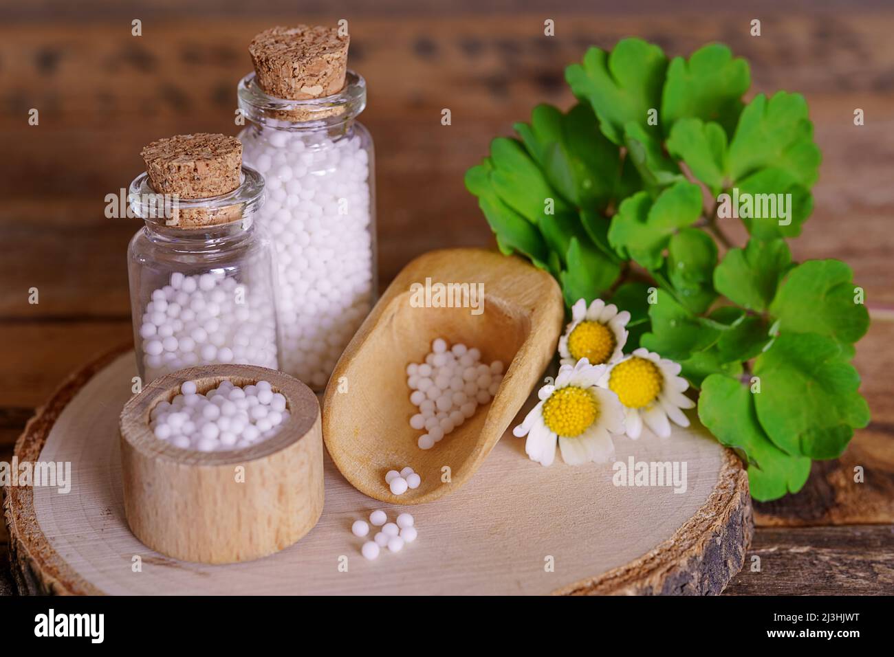 Medical glas vials and bowls on wooden table table, filled with ...