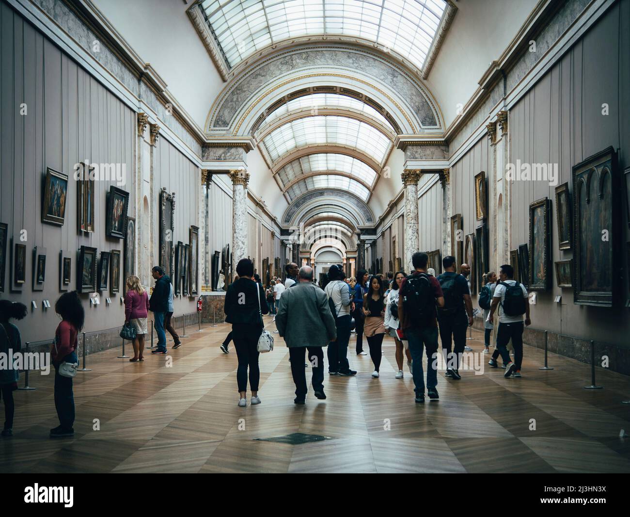 crowd walking through art gallery with glassy roof Stock Photo - Alamy