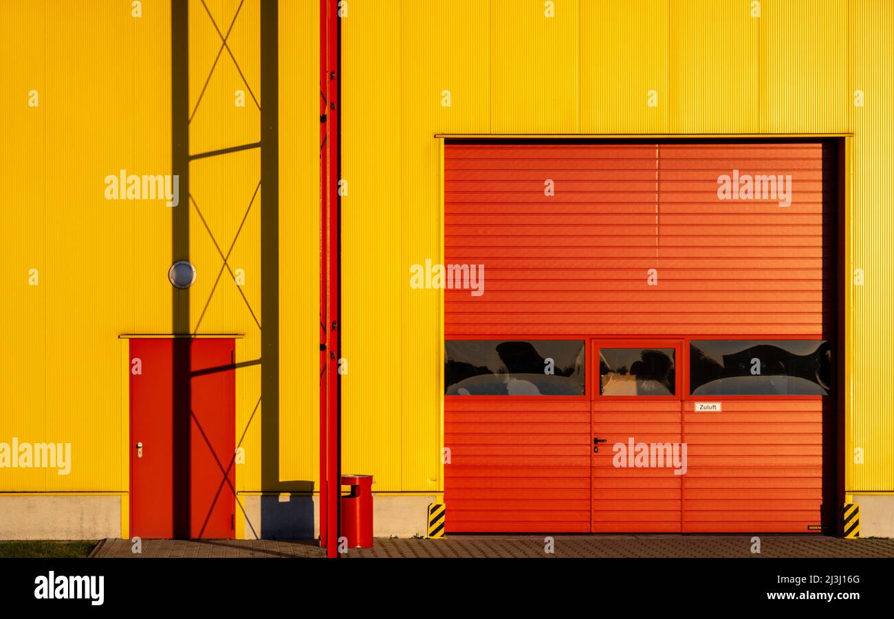 yellow warehouse, red gate, shadow Stock Photo - Alamy