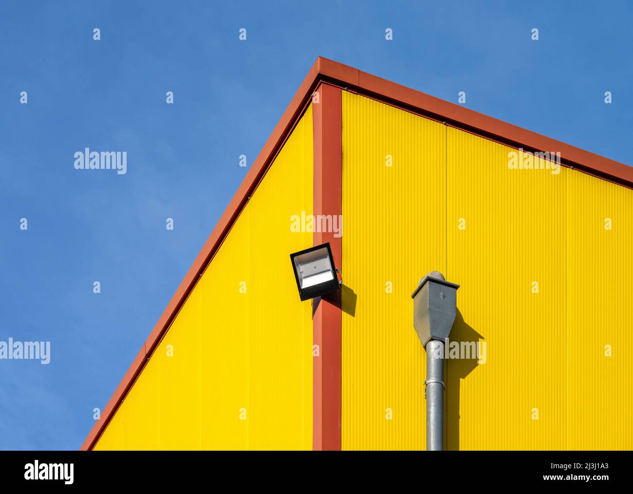 yellow warehouse, blue sky, spotlight Stock Photo - Alamy