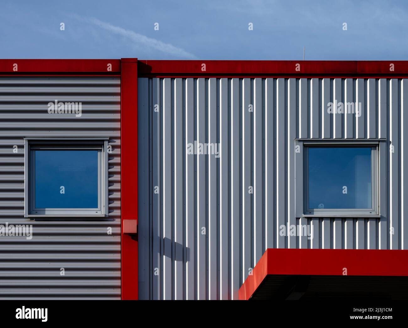Corrugated metal building, red frames, windows Stock Photo - Alamy