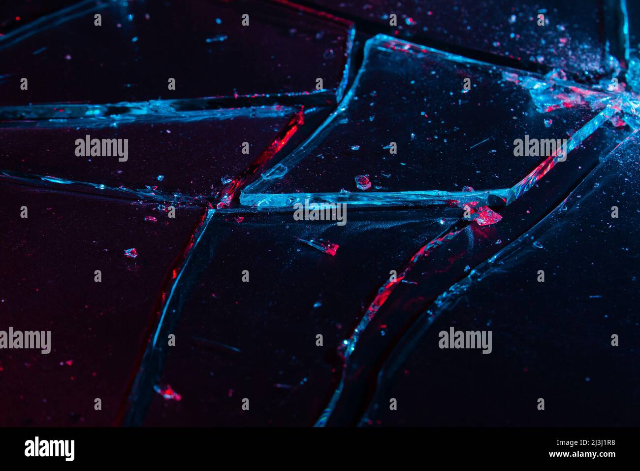Close-up photo texture of blue and red toned broken and cracked glass ...