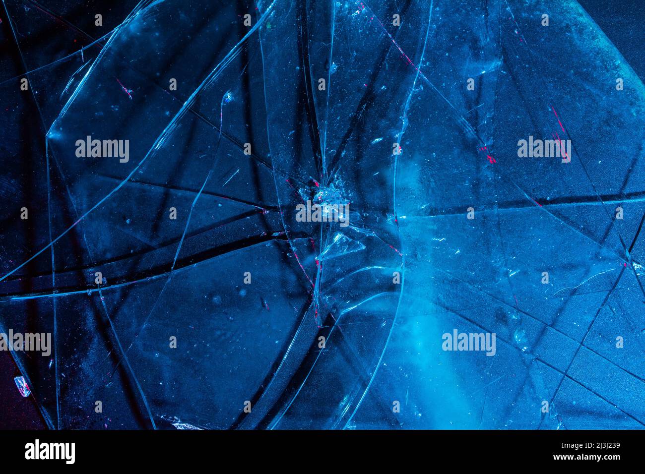 Close-up photo texture of blue and red toned broken and cracked glass ...