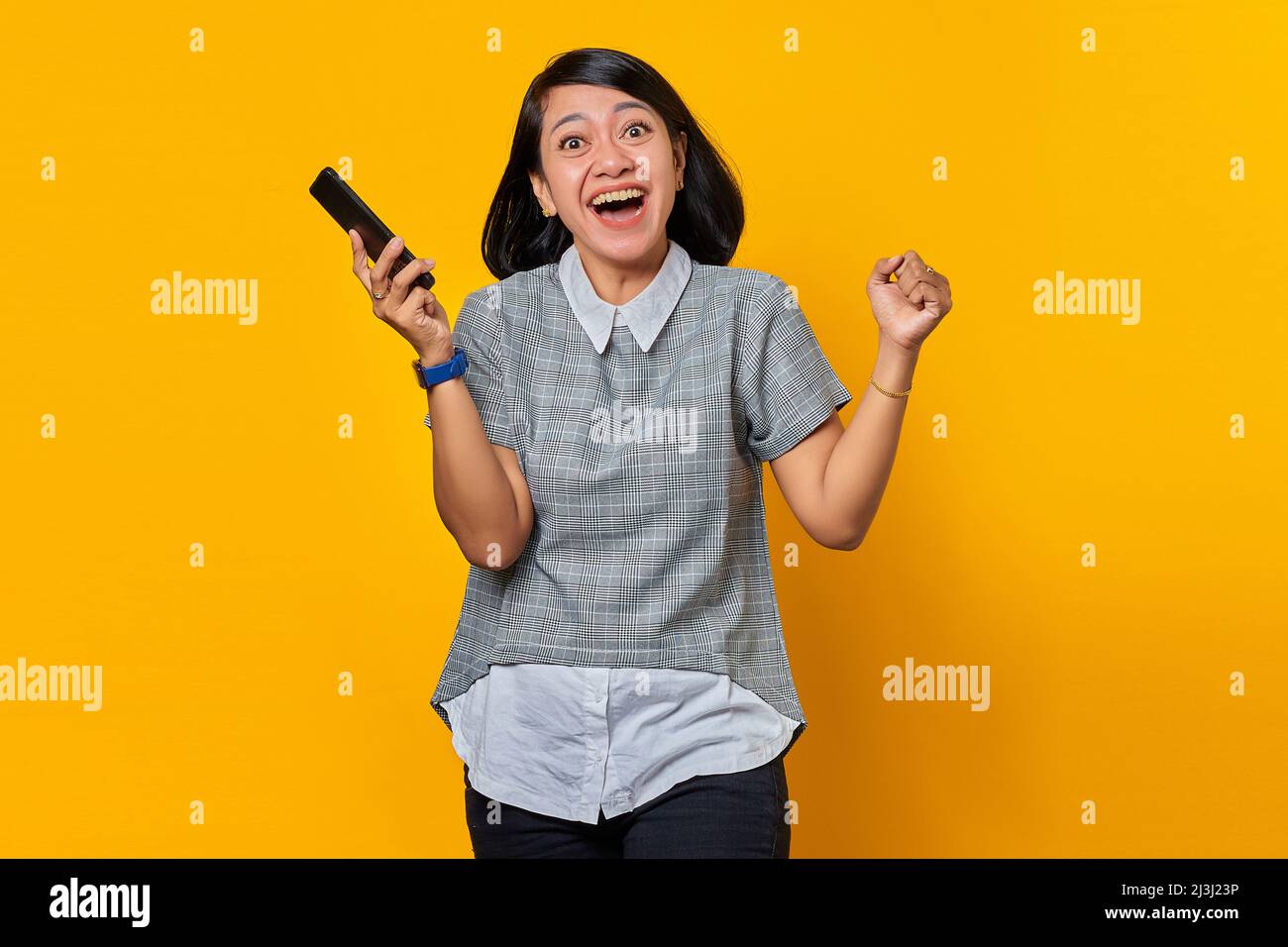 Young Asian woman feeling excited and happy while looking at messages ...