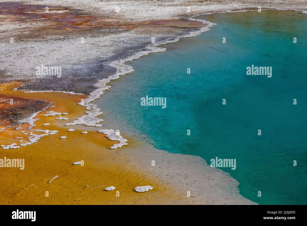 Black Pool with shore of orange thermophiles in the West Thumb Geyser ...