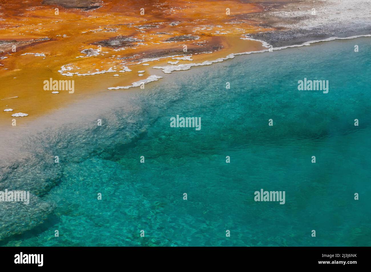 Black Pool with shore of orange thermophiles in the West Thumb Geyser ...