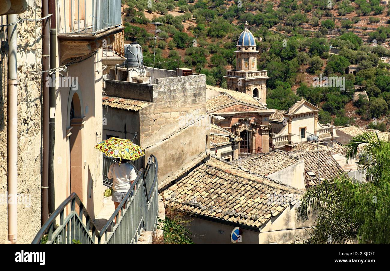 tourist with sun umbrella visit Ragusa Ibla historic center with the ...
