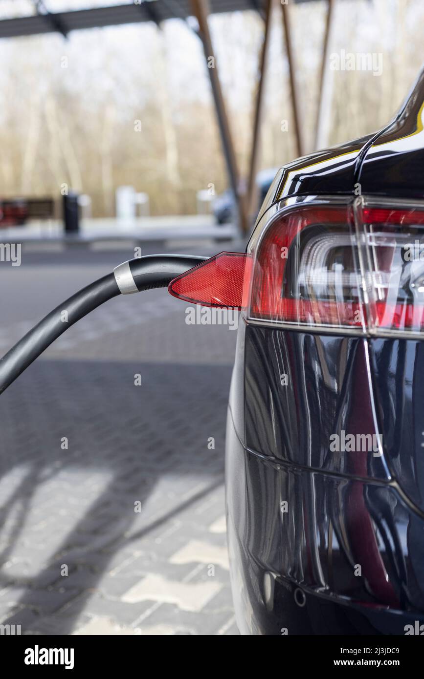 Rear view of a Tesla Model S charging at a charging station in Germany ...