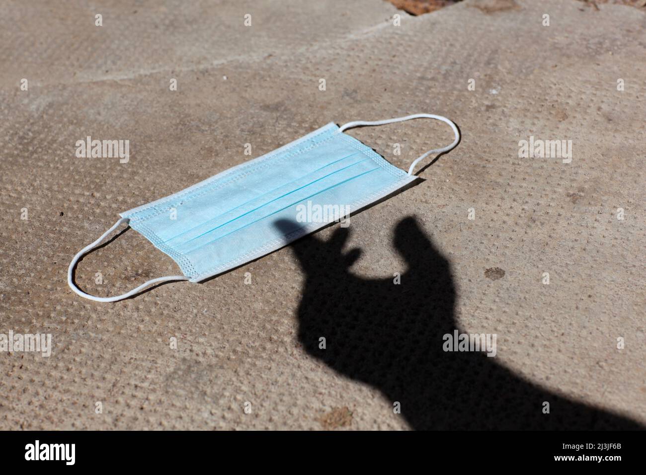 Shadow hand grabs mask Stock Photo - Alamy