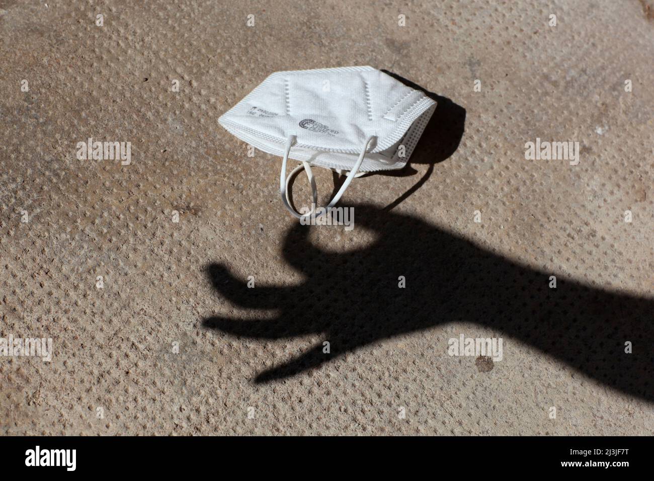 Shadow hand grabs mask Stock Photo - Alamy