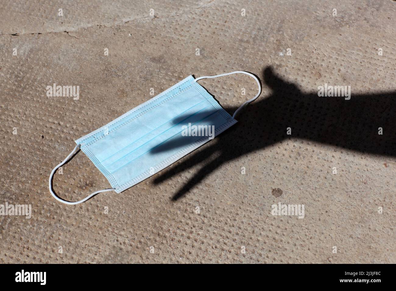 Shadow hand grabs mask Stock Photo - Alamy