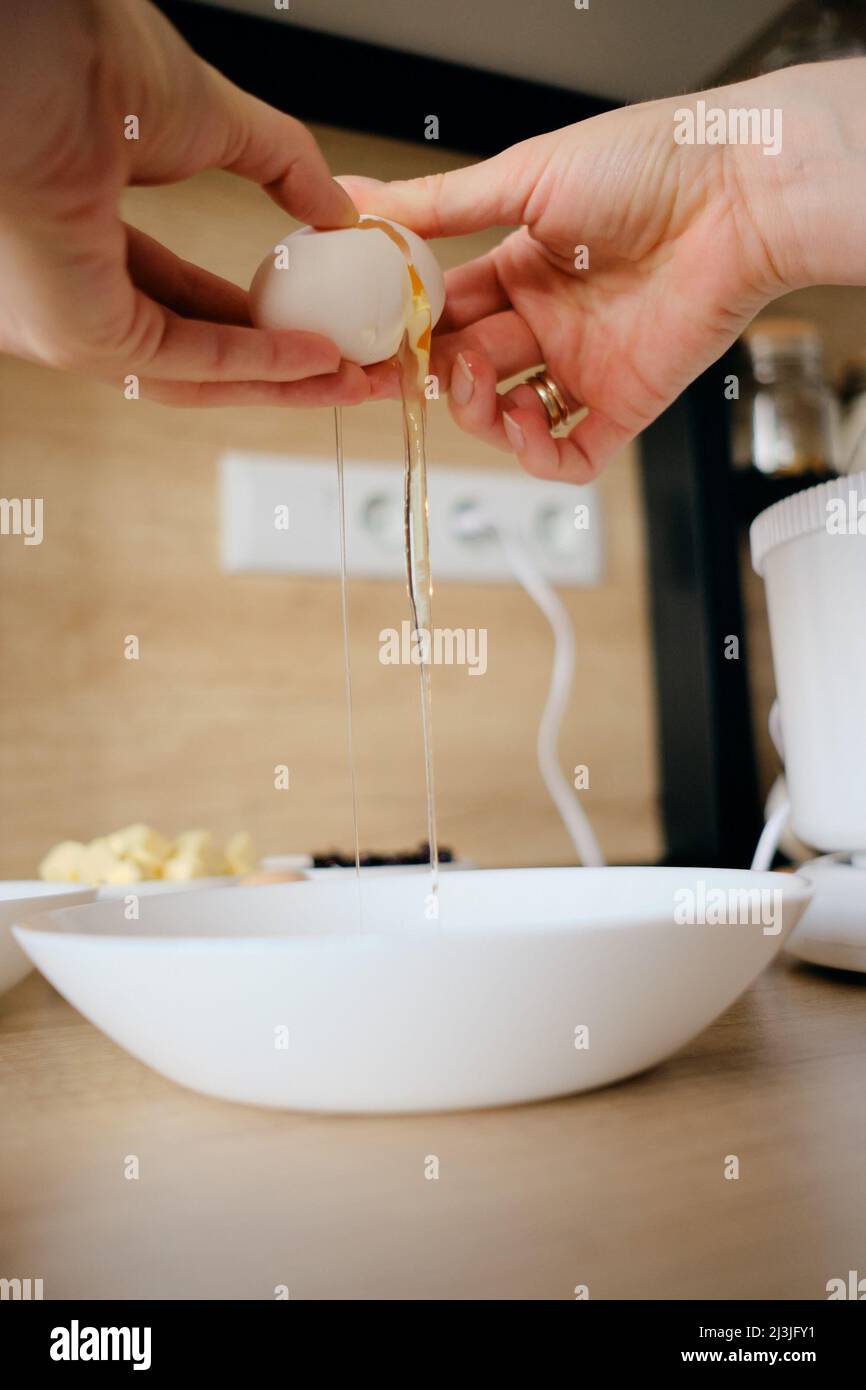 Close up woman hands break chicken eggs in a plate in the kitchen. Cooking dough Stock Photo - Alamy
