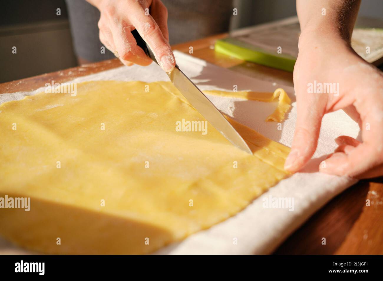 Close up woman hands, cutting dough in the sunlight on the table Stock ...