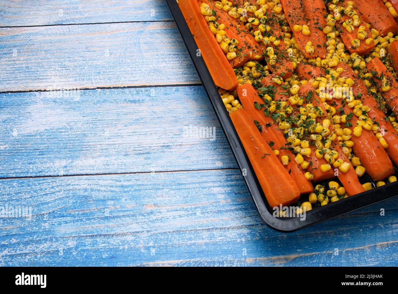 background stewed red carrots with yellow corn on a baking sheet Stock ...