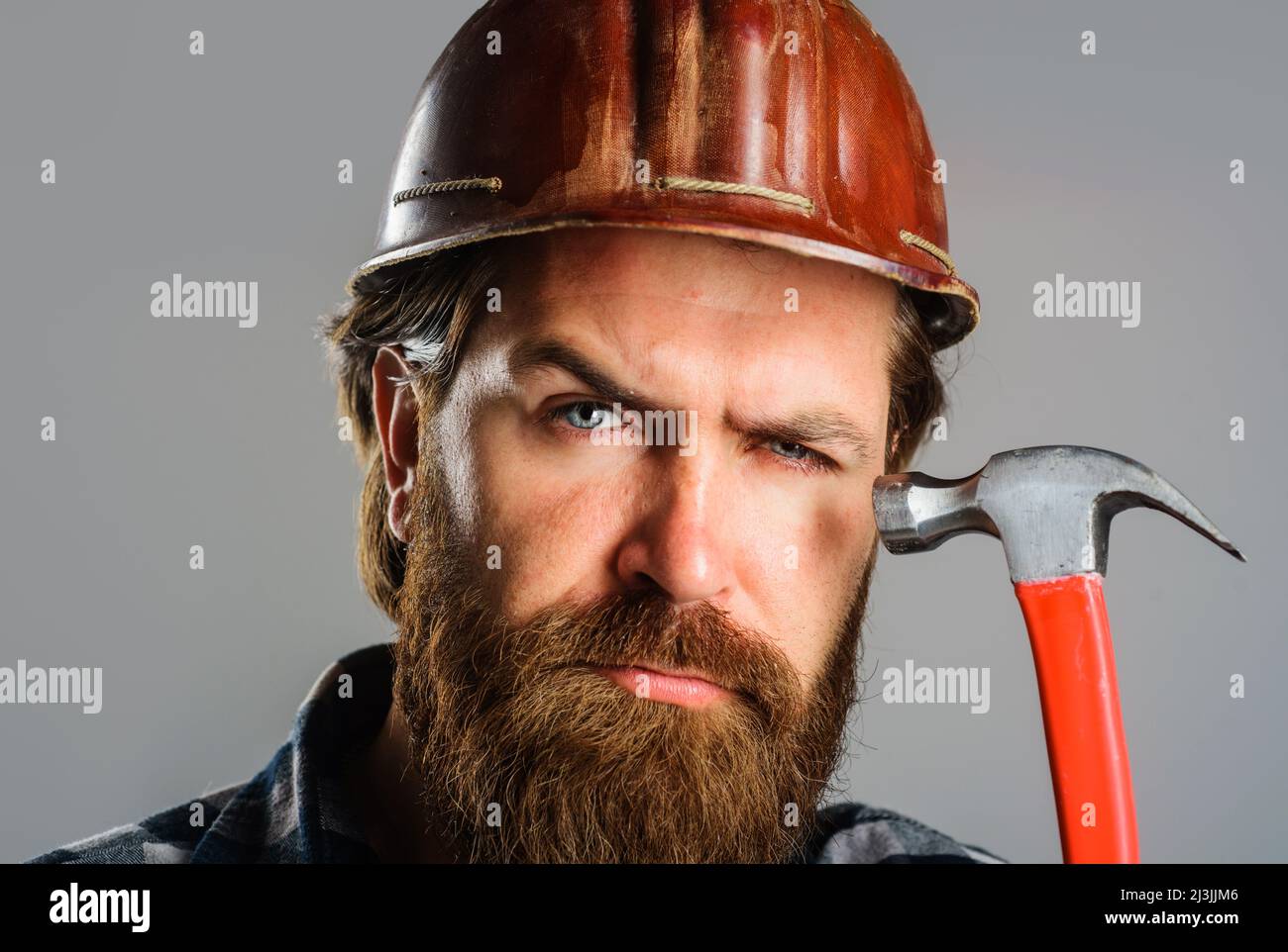 Bearded worker with hammer. Builder or carpenter in hard hat with ...