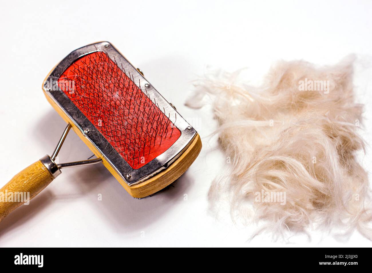 Animal brush for dog and cat grooming with fur on light table ...