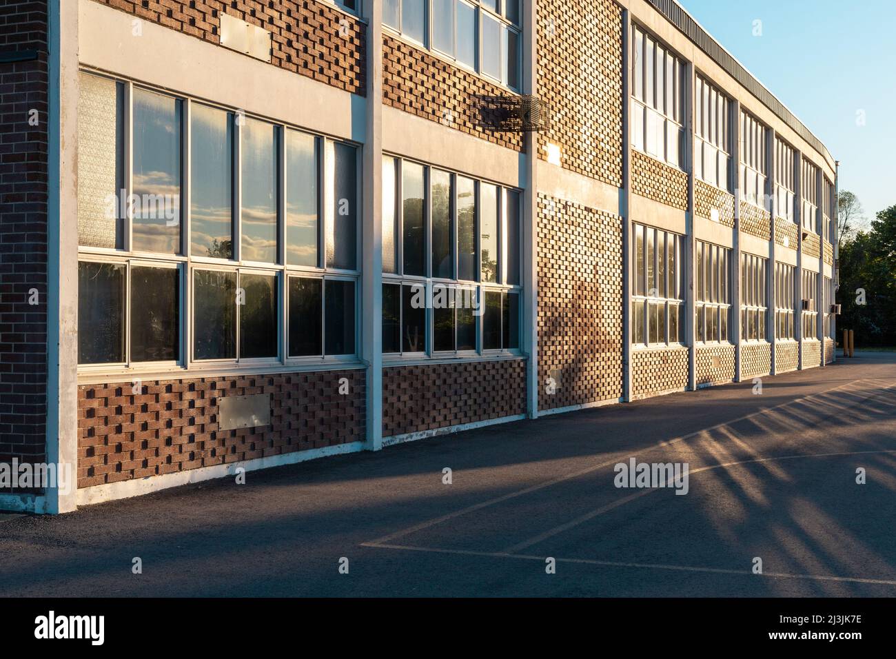 School building and school yard in the evening with sun reflecting in ...