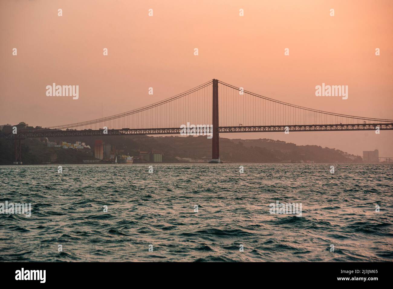 The 25 de Abril Bridge supension bridge of Lisbon at Sunset. Beautiful ...