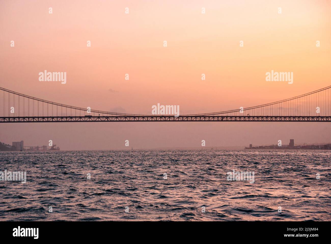 The 25 de Abril Bridge supension bridge of Lisbon at Sunset. Beautiful ...