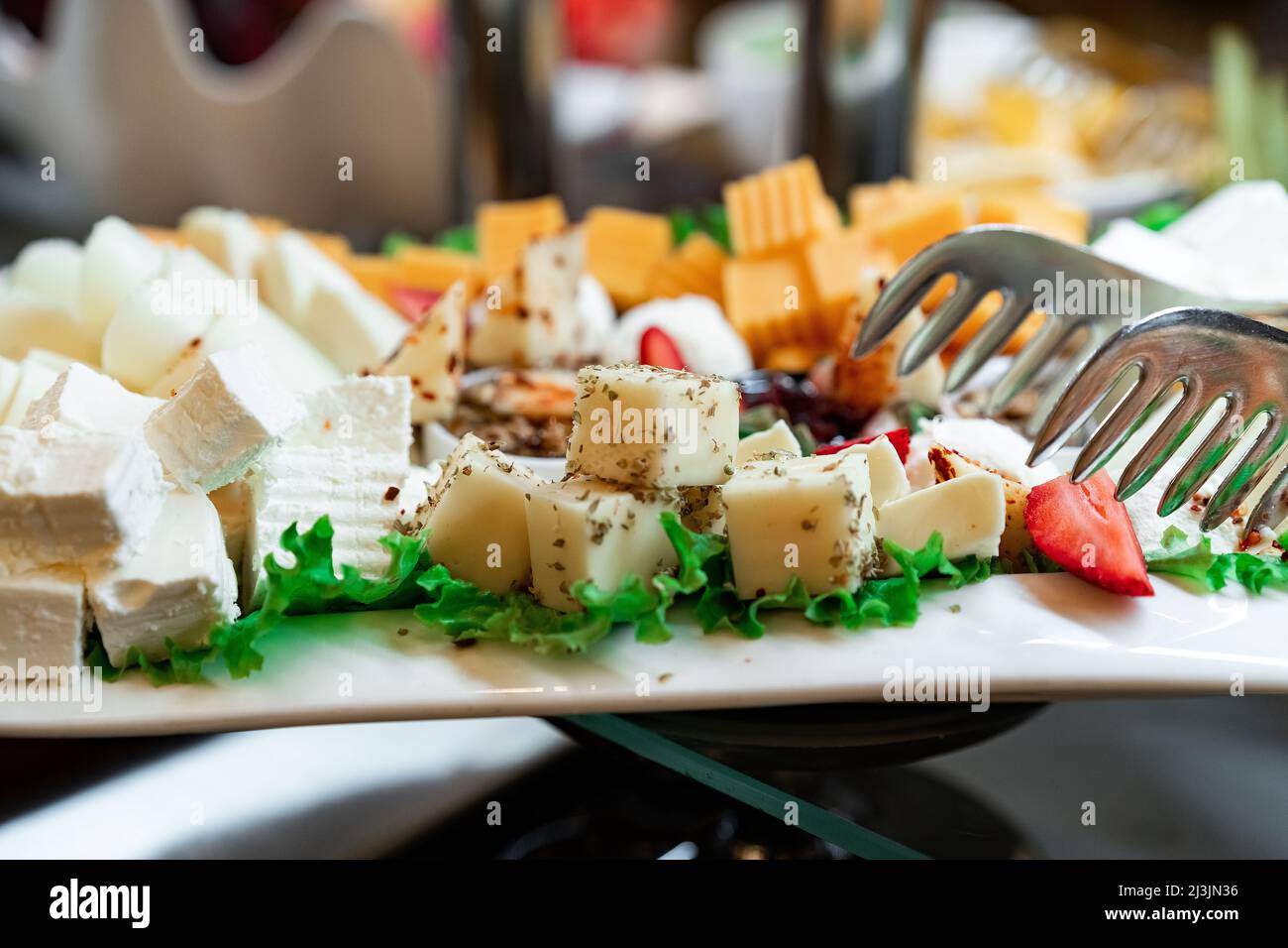 Plate with cheese and salad Different types of cheese in different ...