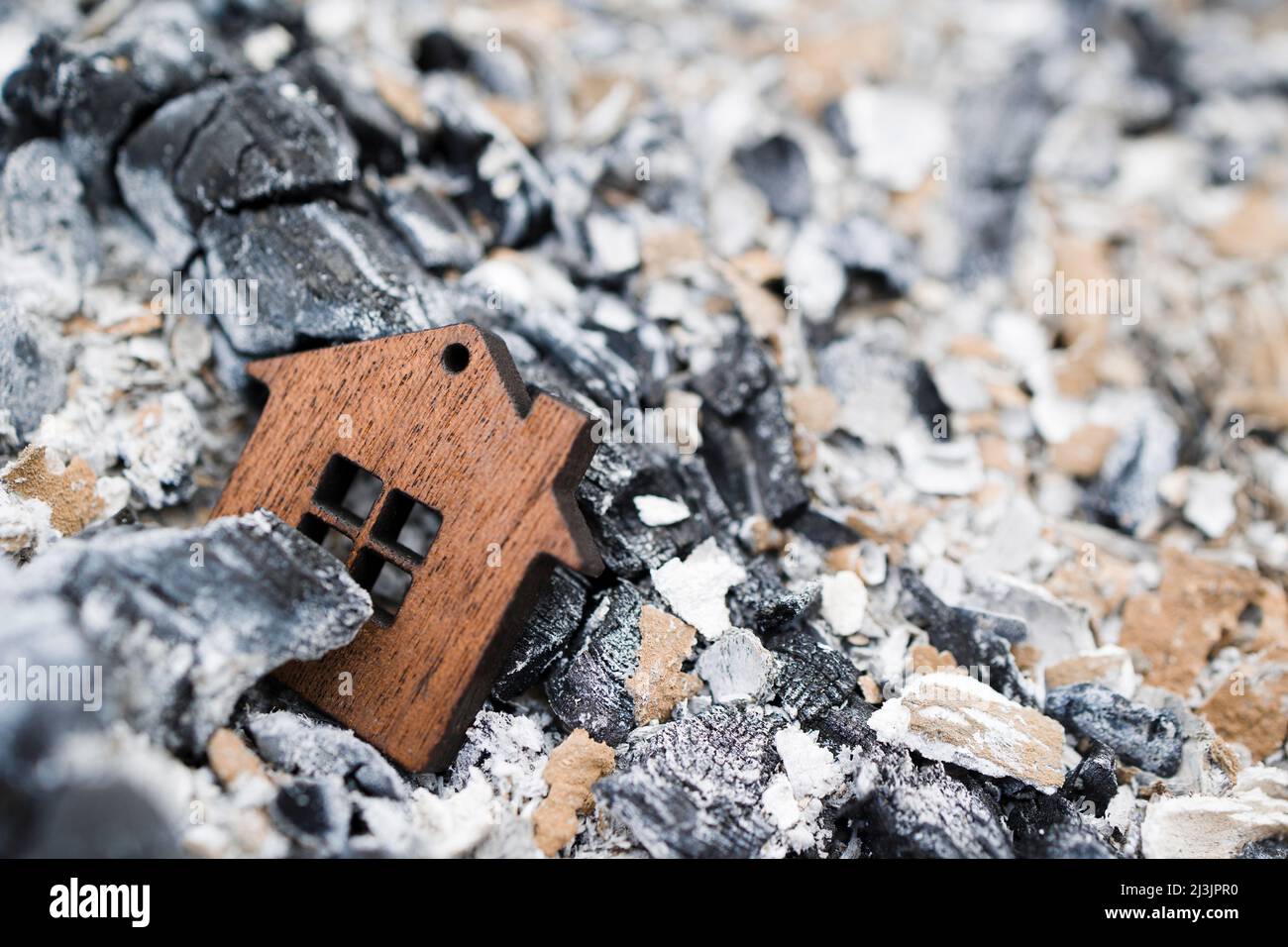 Tiny wooden house on an ash . Home Fire concept Stock Photo - Alamy