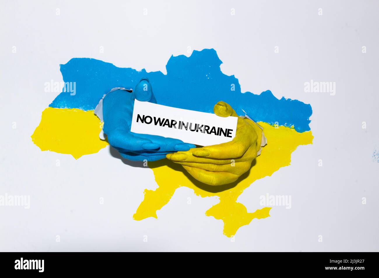 Female hands painted in color with flag of Ukraine. Drawing map of ...