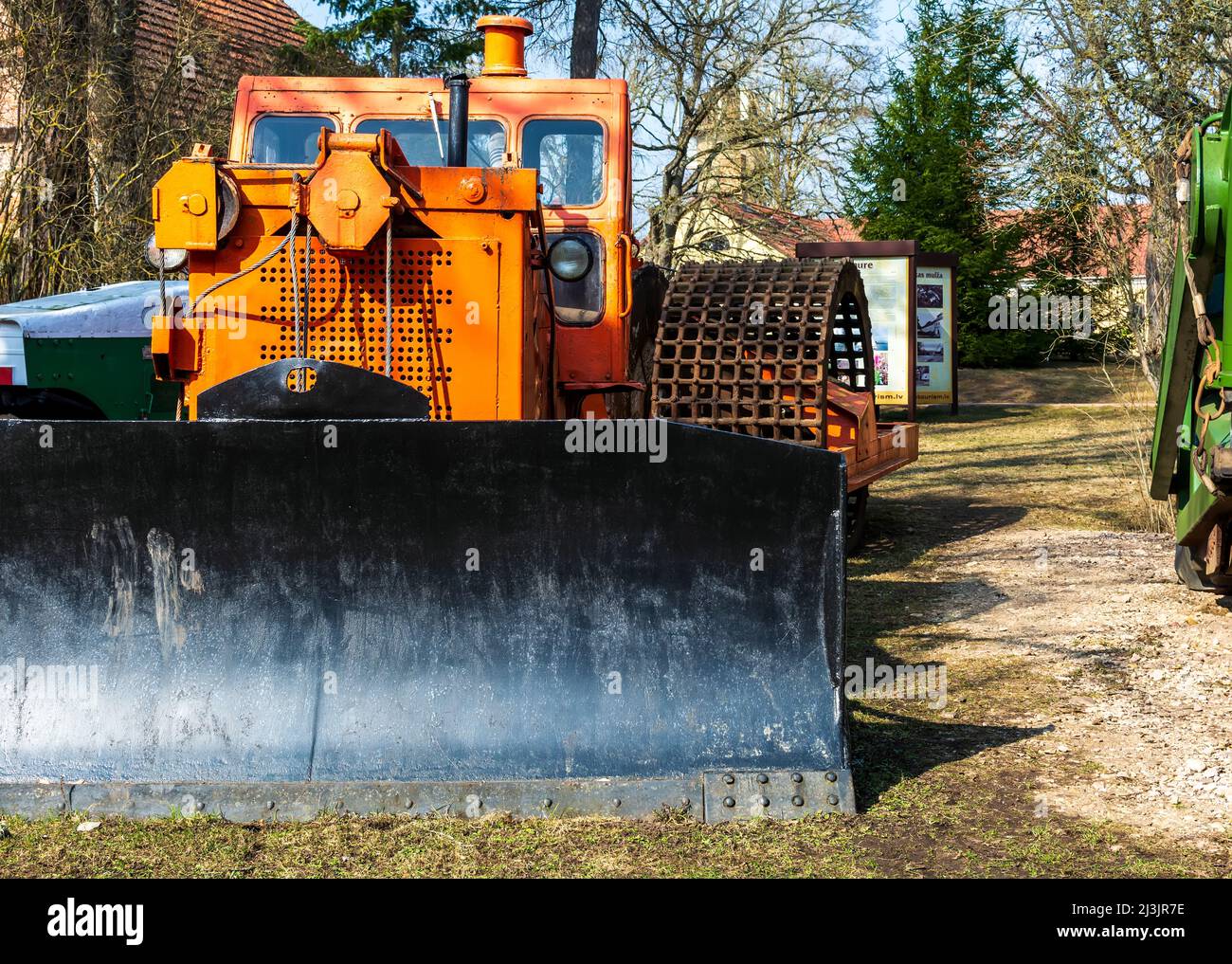 Old orange powerful bulldozer with black bucket in front for road ...