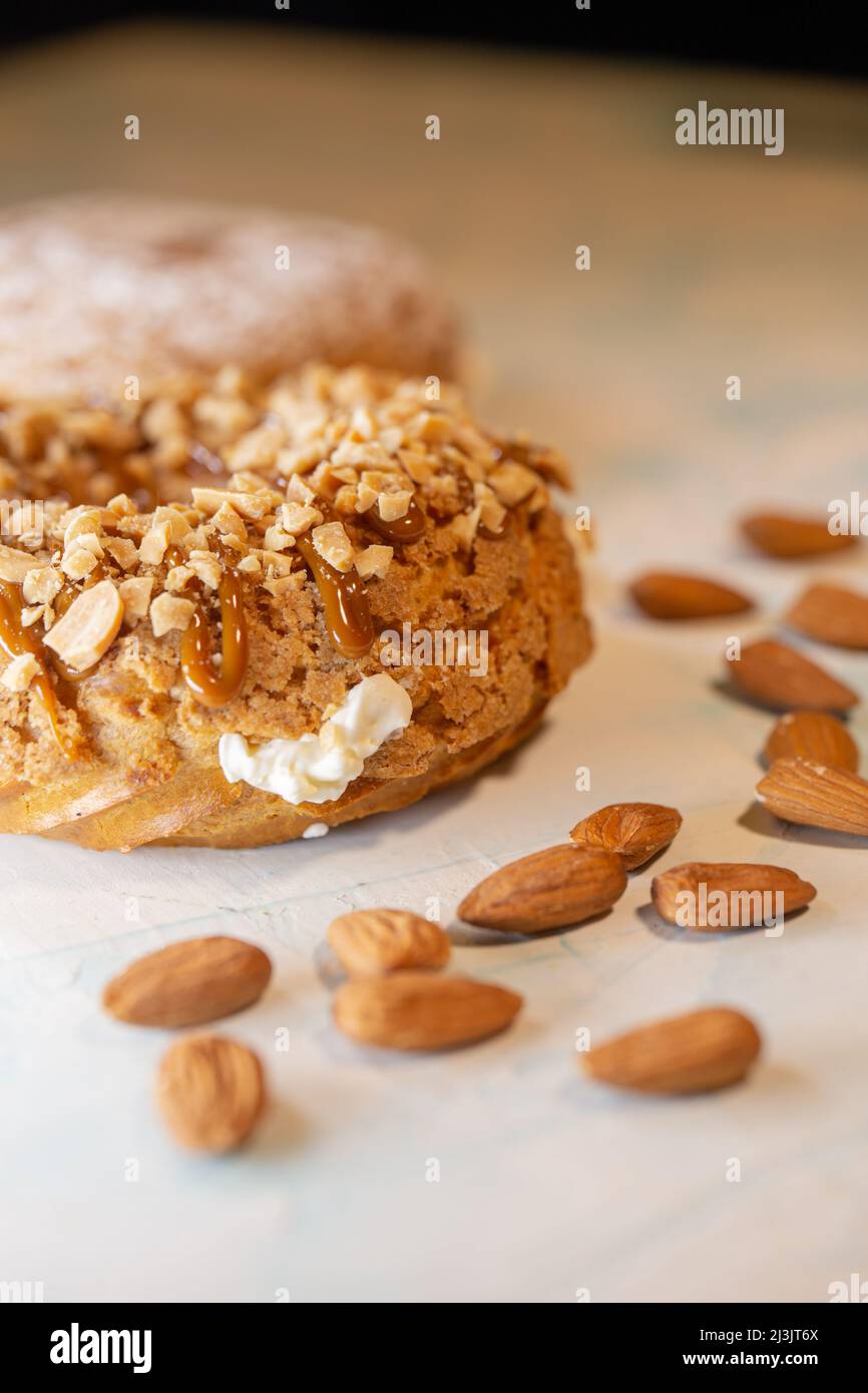 A piece of delicious handmade donut with nuts close-up Stock Photo - Alamy