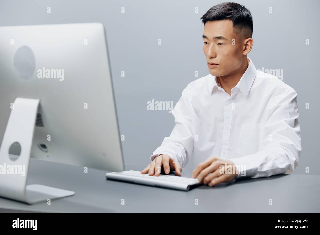 man in a white shirt works at a computer in the office Lifestyle work ...