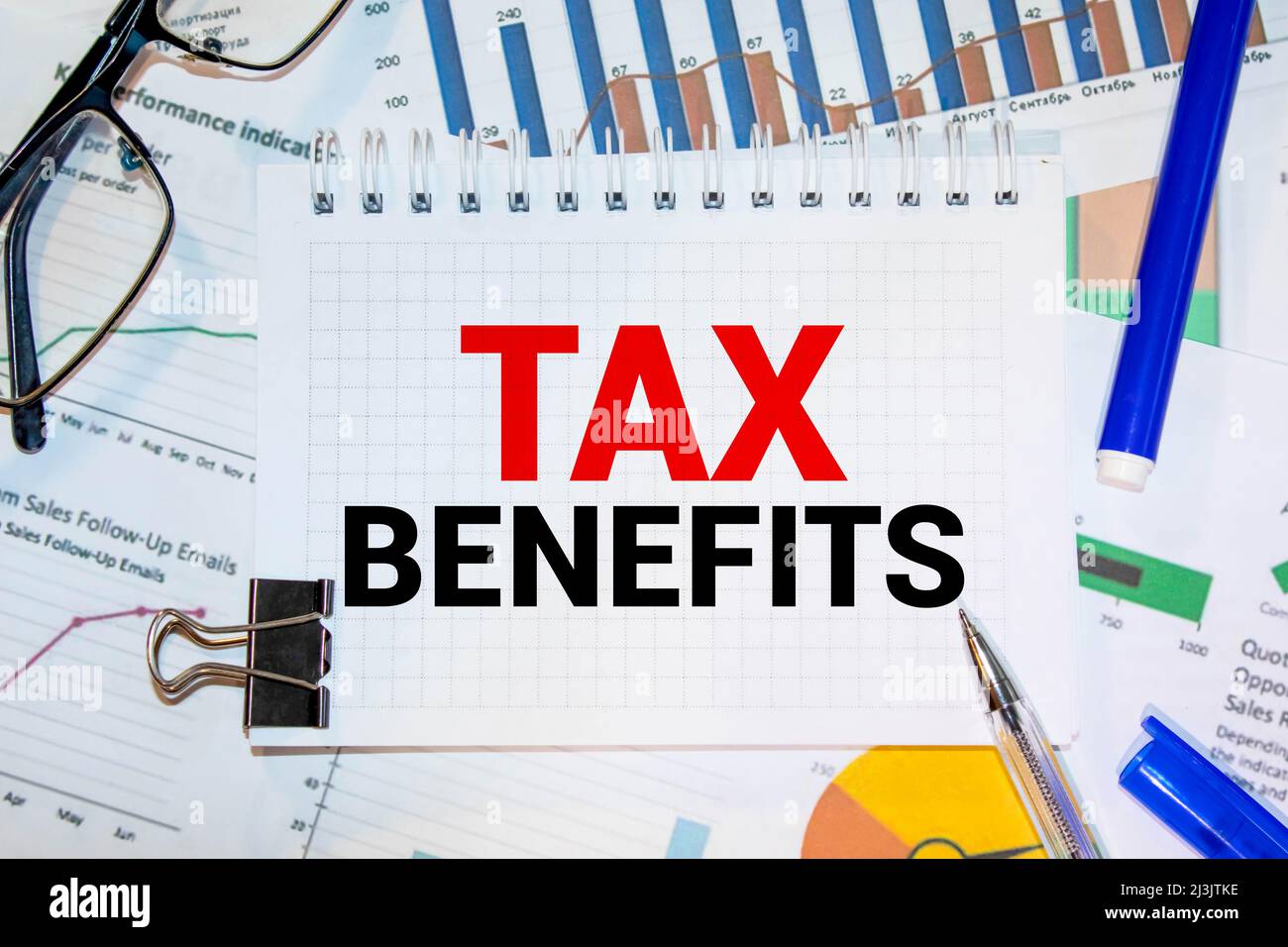 Closeup on businessman holding a card with text TAX BENEFITS, business ...